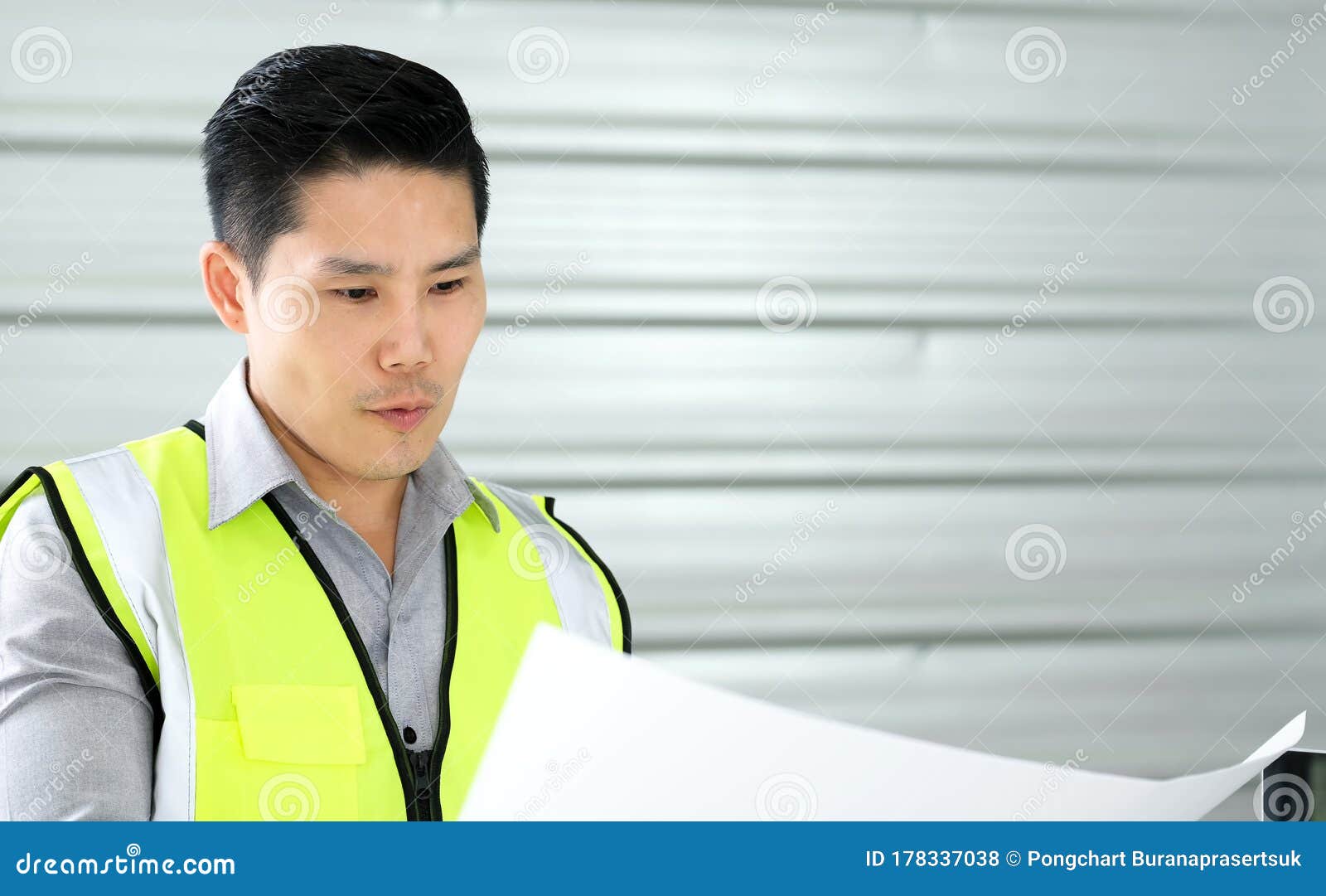 Engineer Man Standing in the Office and Look Information on Blueprint ...