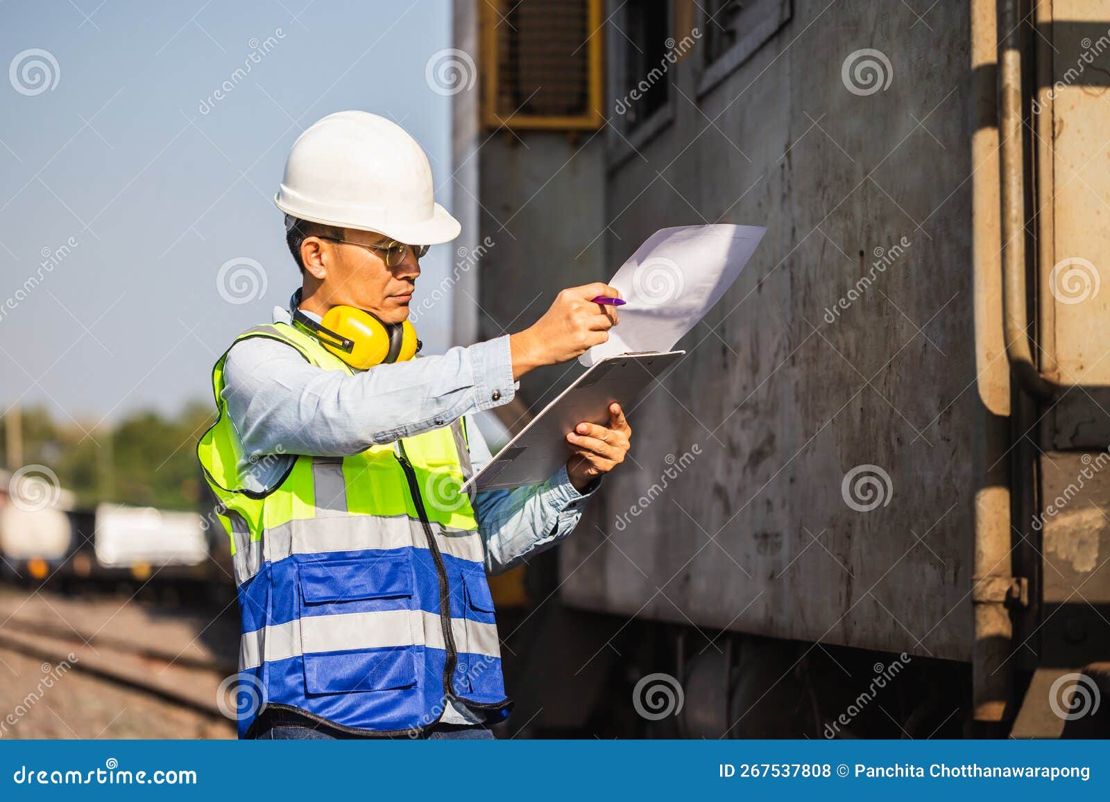 Engineer Man in Waistcoats and Hardhats and with Documents in a Railway ...