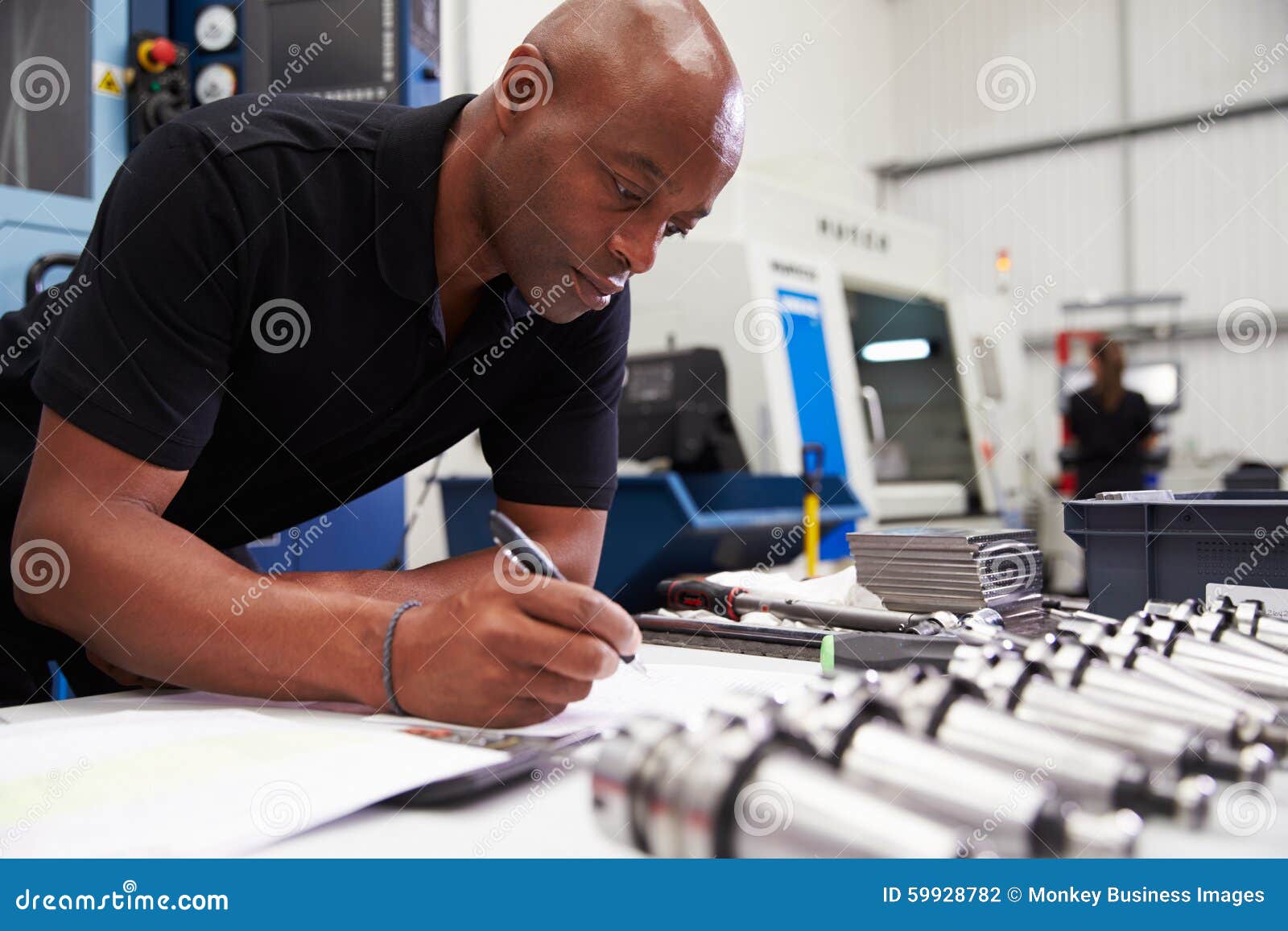 Engineer Planning Project with CNC Machinery in Background Stock Photo ...