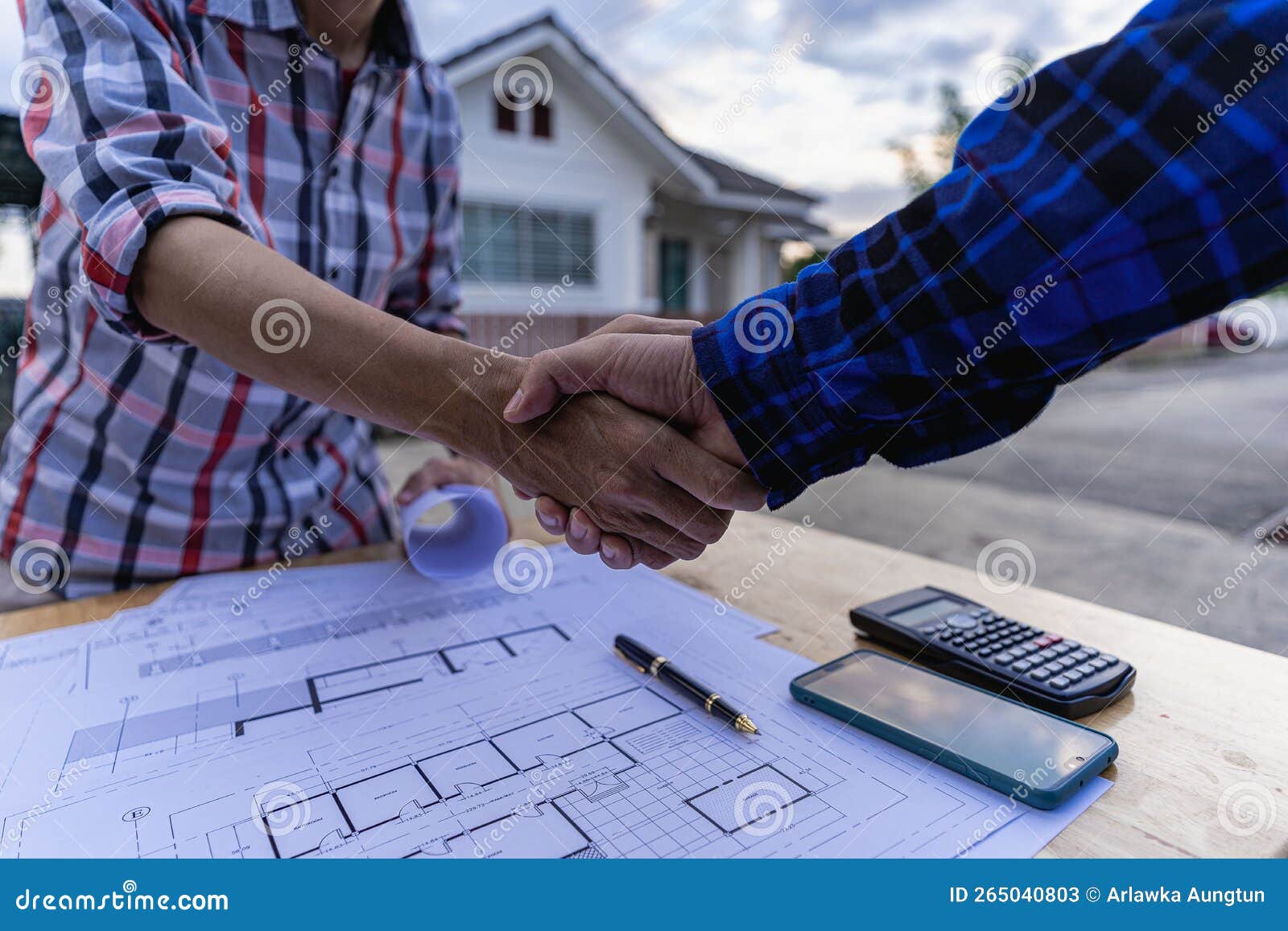 Engineer Pointing at Blueprint and Using Laptop To Draw Building Design ...