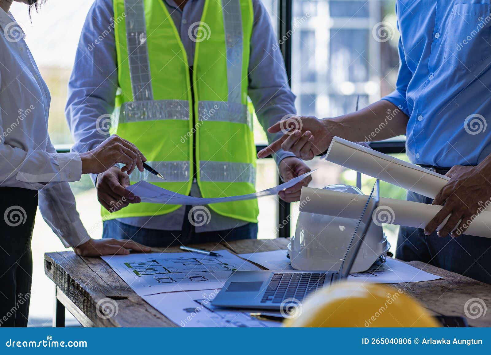 Engineer Pointing at Blueprint and Using Laptop To Draw Building Design ...