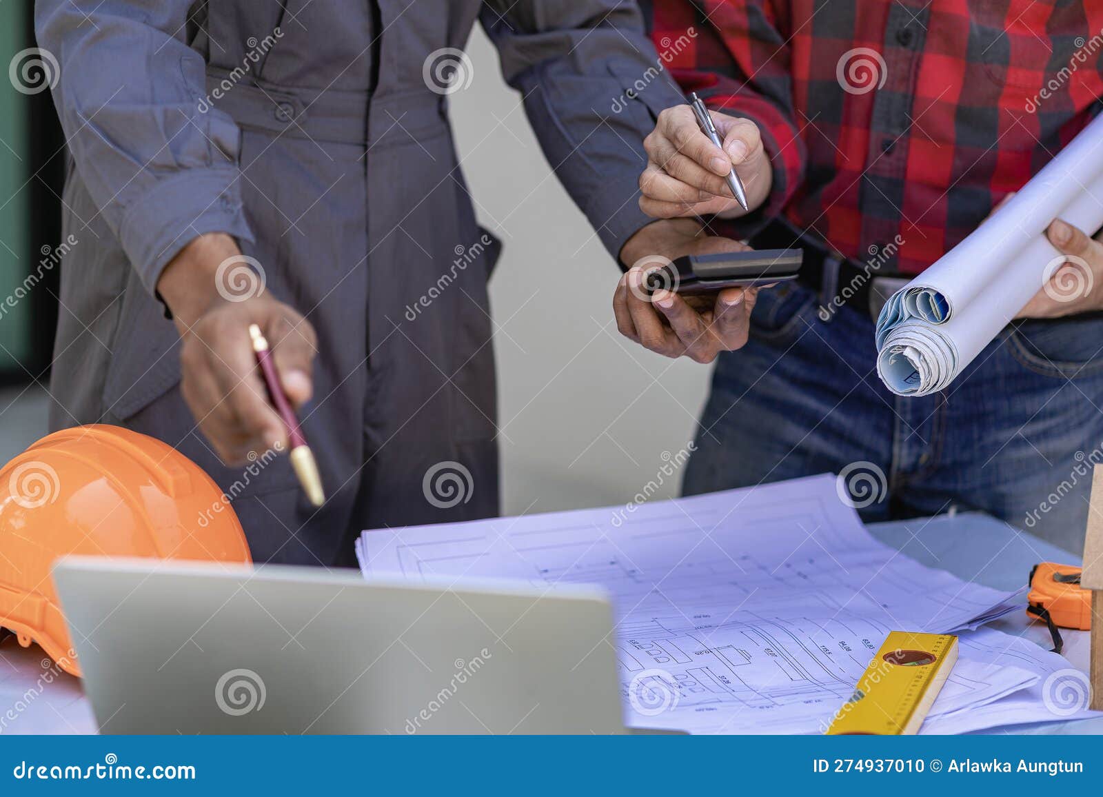 Engineer Pointing at Blueprint and Using Laptop To Draw Project Design Building Construction ...