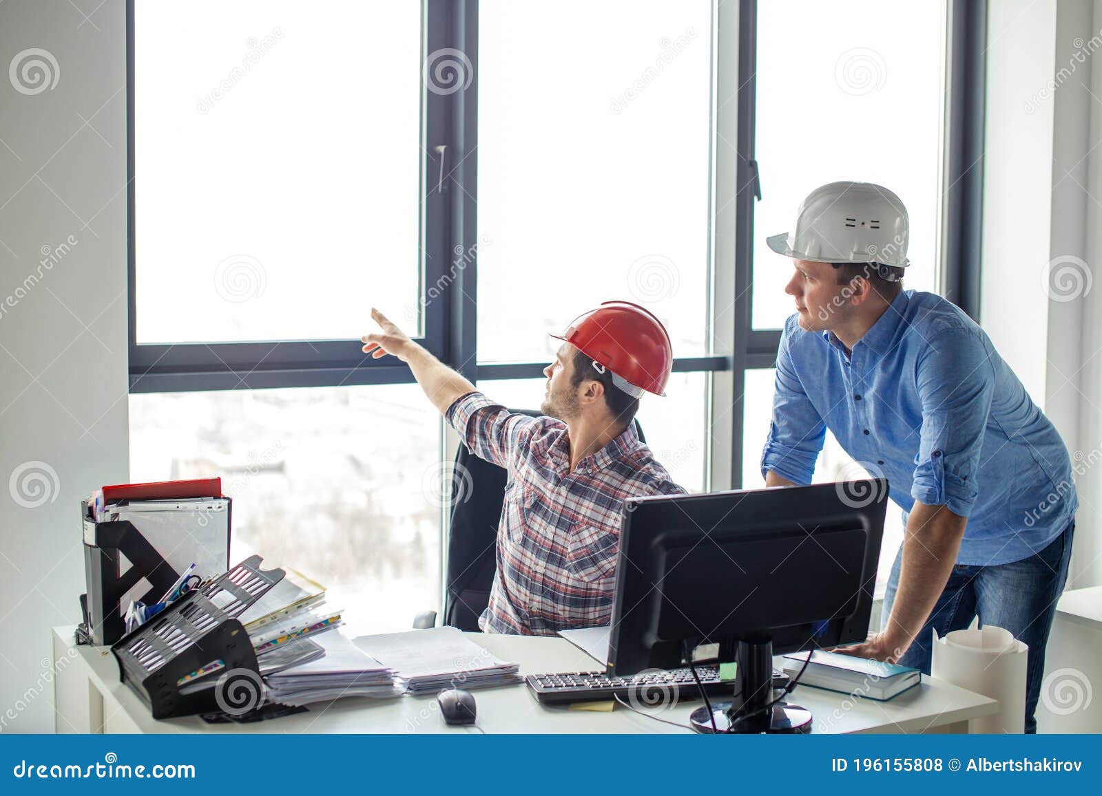 Engineer is Pointing at the Window while Sitting in Front of the ...