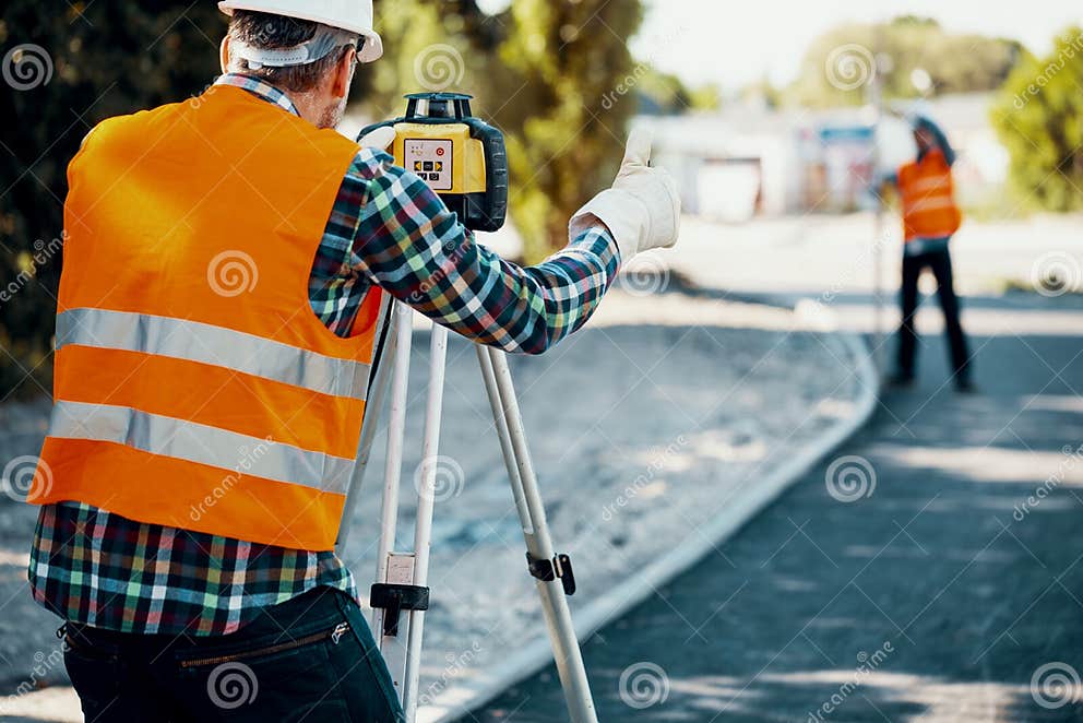 Engineer in Reflective Vest Using Equipment during Geodetic Work Stock ...