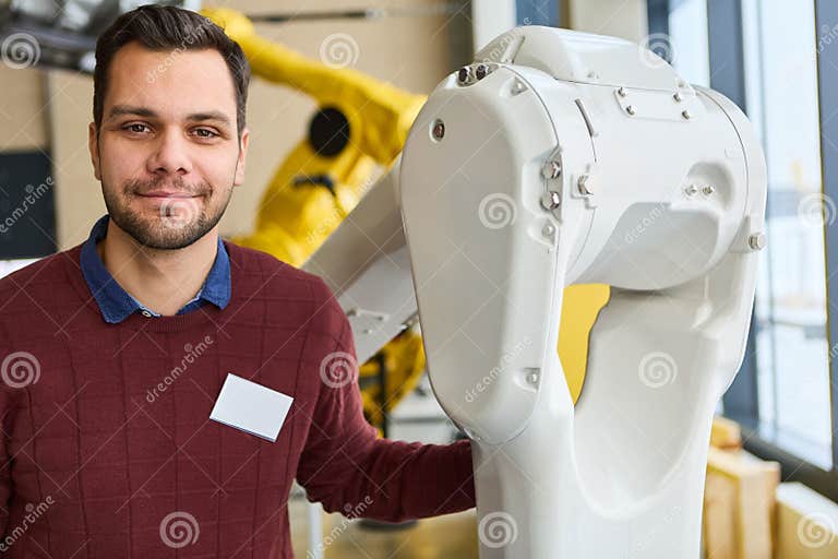 Engineer with Robot Arm in Industrial Setting, Focusing on Robotics and ...