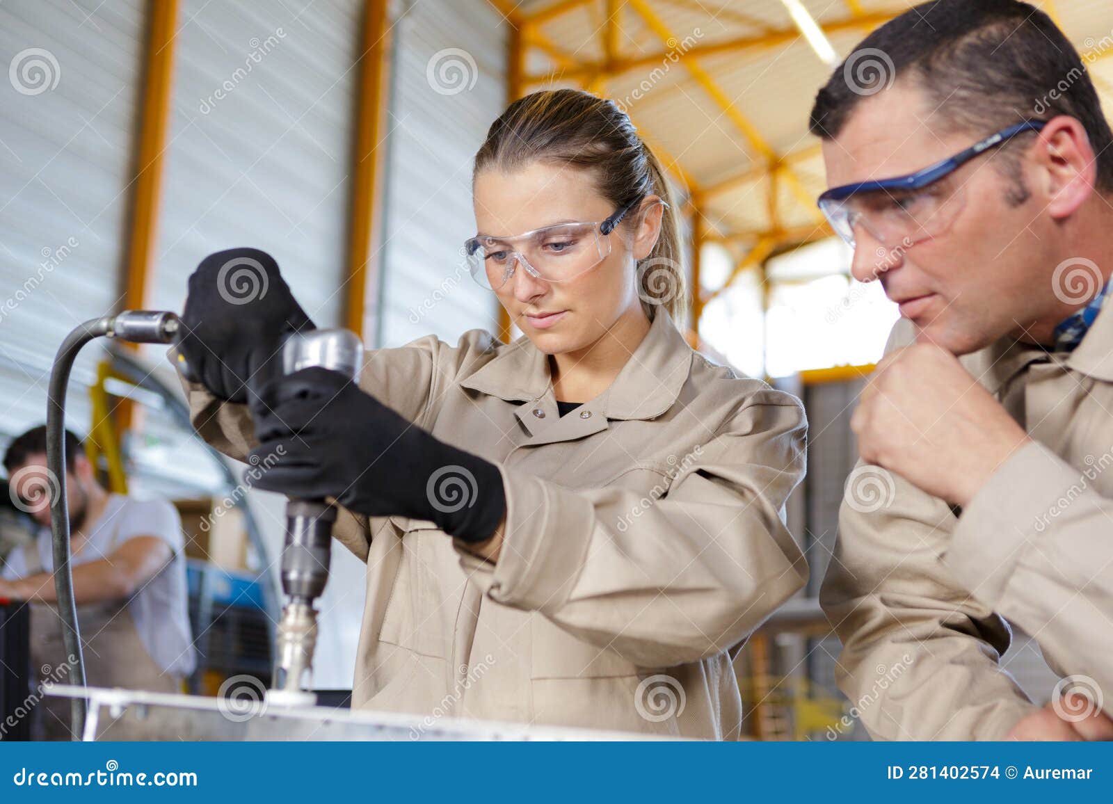 Engineer Showing Female Apprentice How To Use Drill in Factory Stock ...