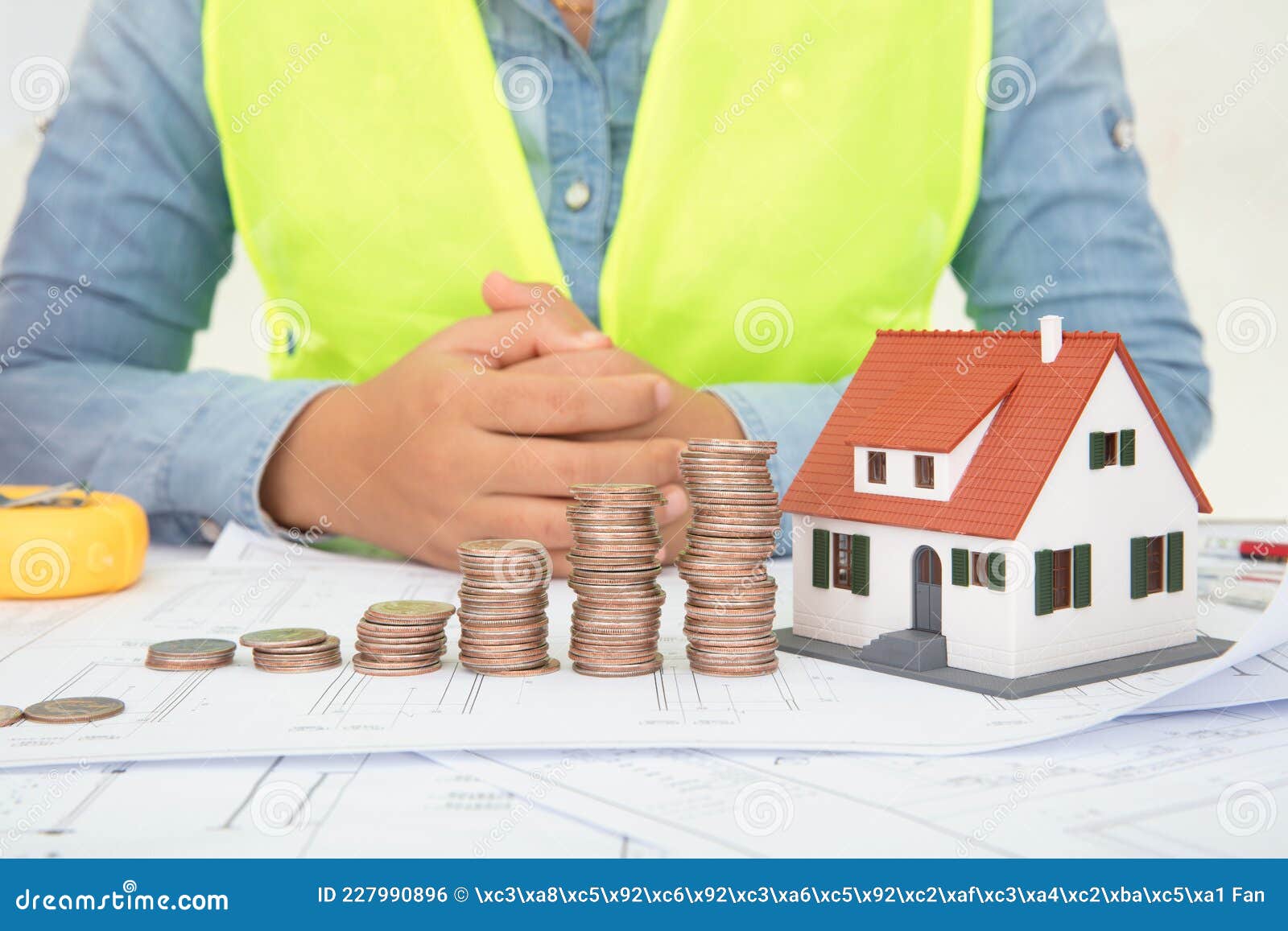 The Engineer Sits in Front of a Table with Drawings and a Small House ...