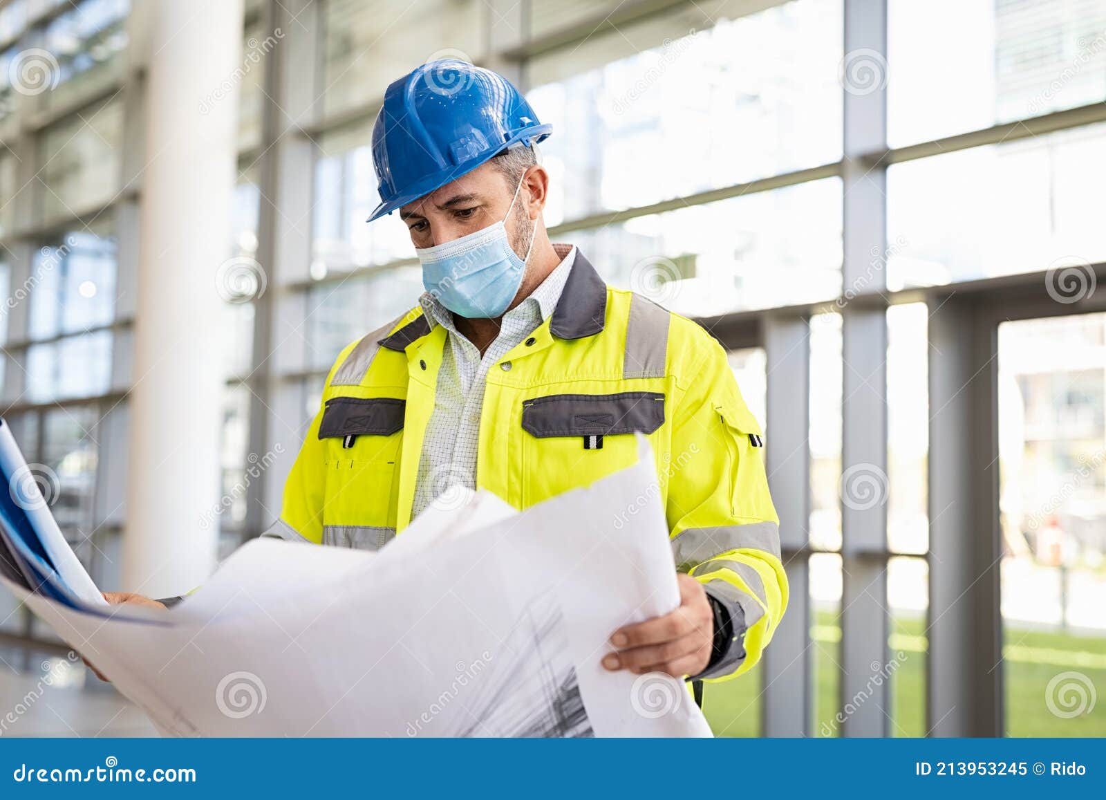 Engineer Studying Plan at Construction Site with Protective Face Mask ...