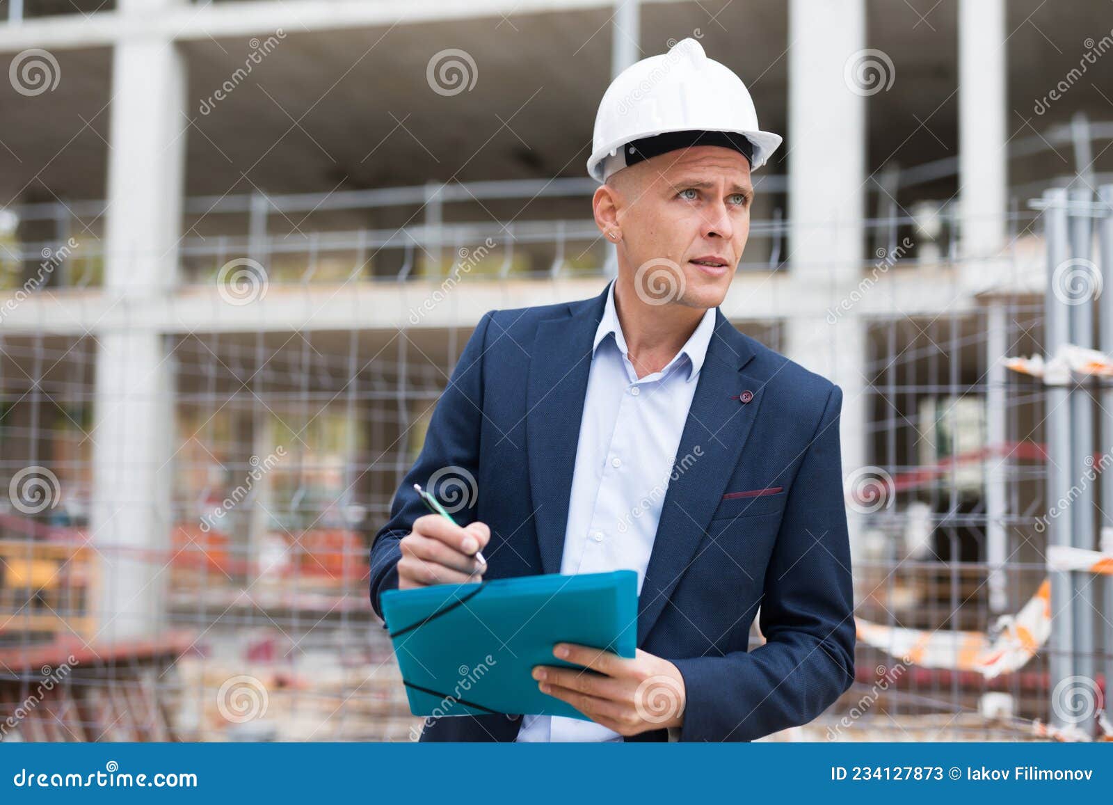 Engineer in Suit Standing in Construction Area with Folder in Hands ...