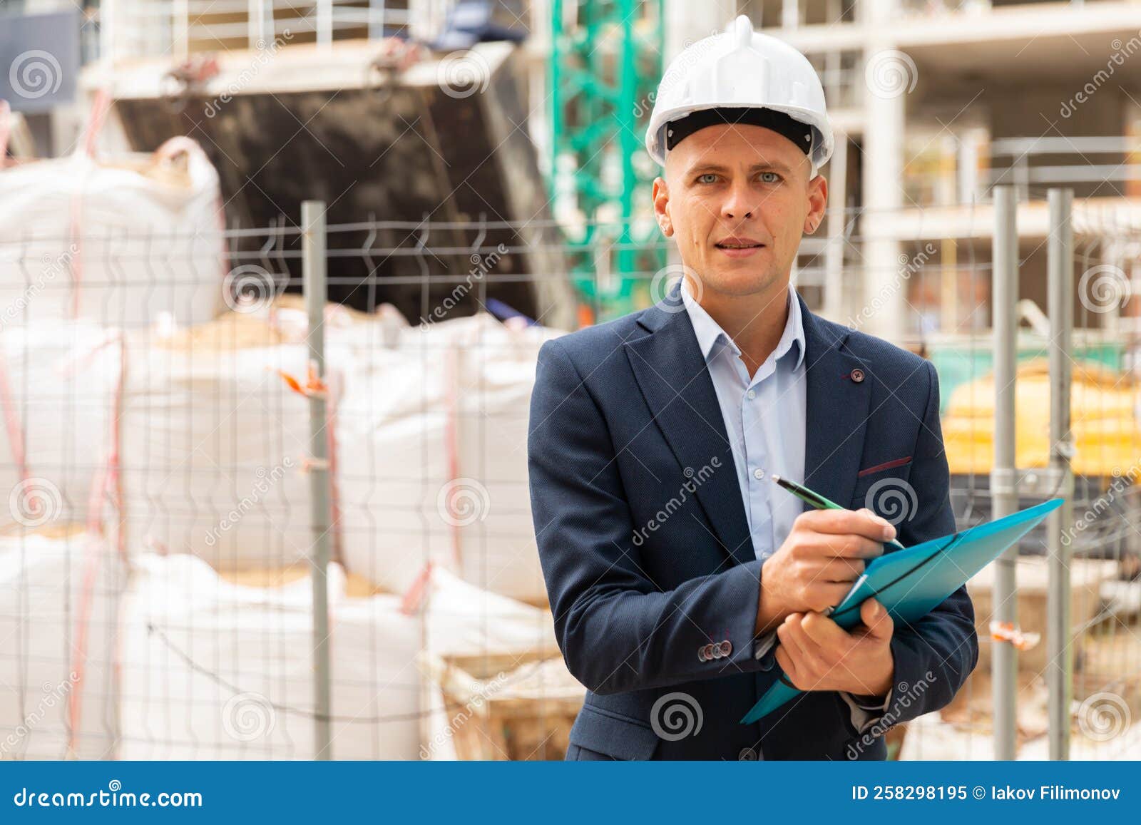 Engineer in Suit Standing in Construction Area with Folder in Hands ...