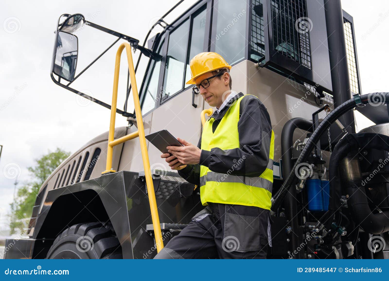 Engineer with Tablet Computer Stands on the Stairs To the Cab of a ...