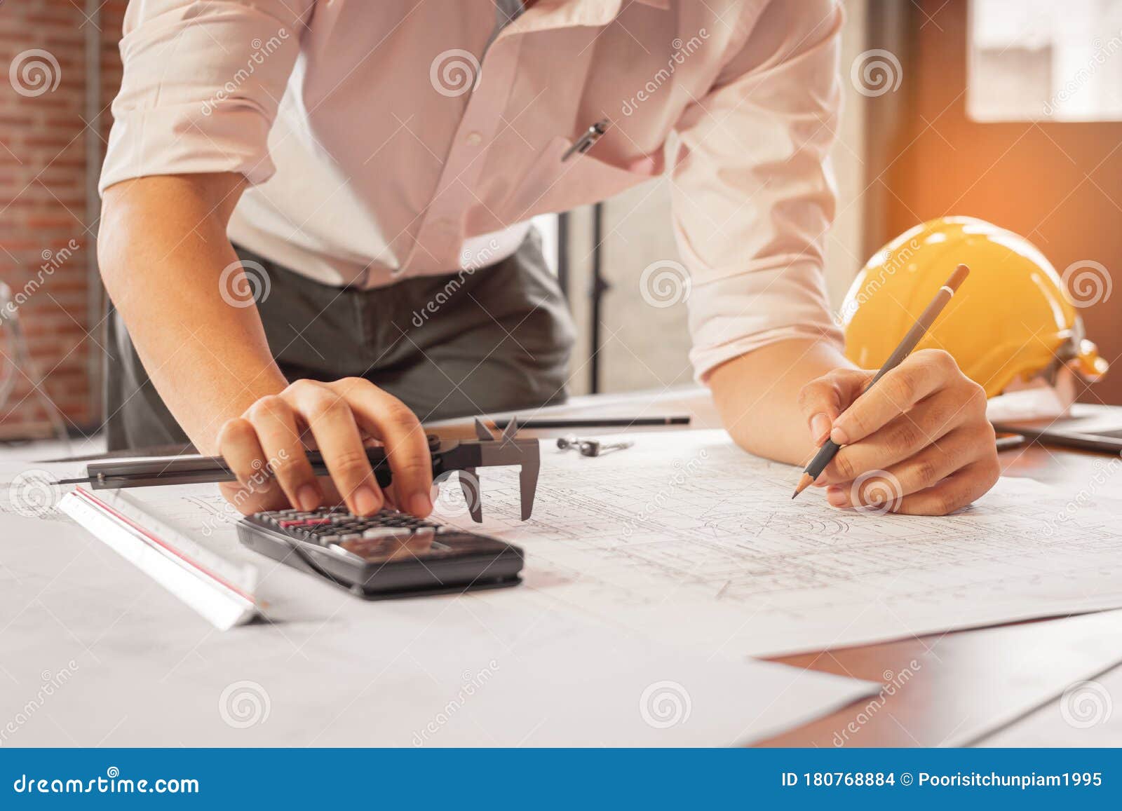 Engineer Using Calculator and Sketching the Drawing Construction ... Engineer Using Calculator and Sketching the Drawing Construction ...