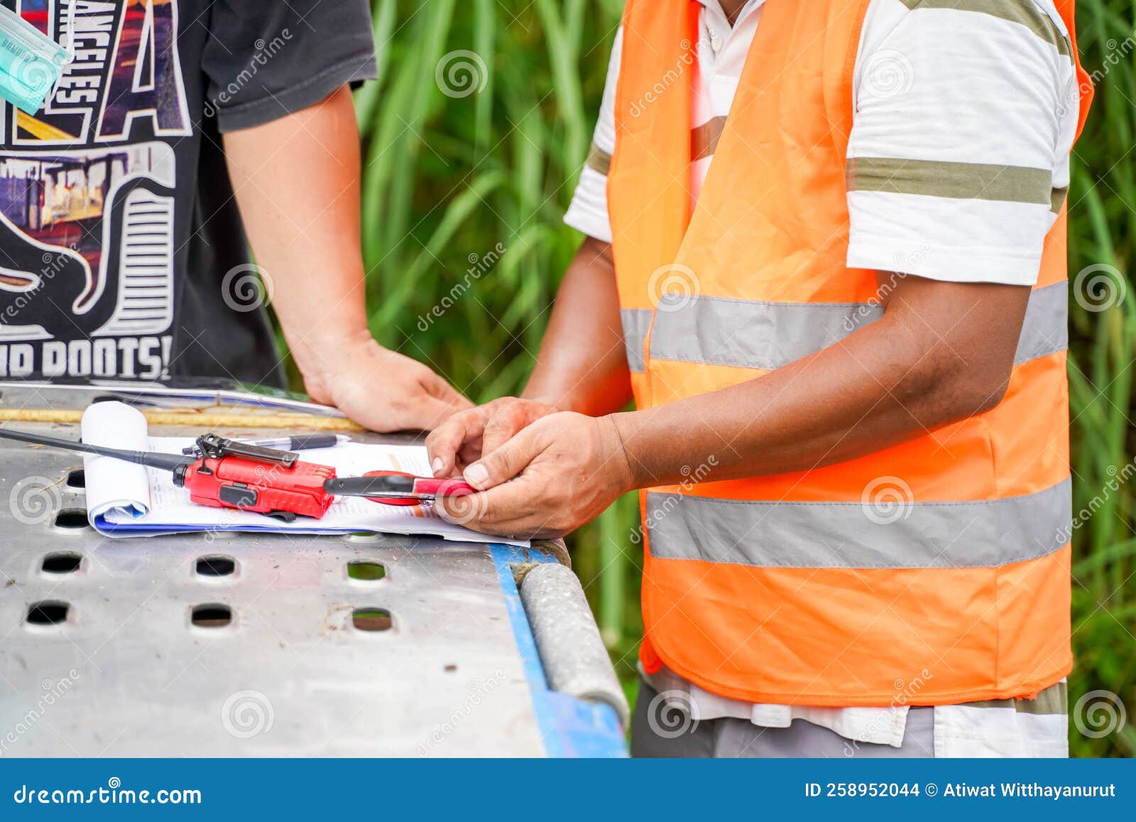 An Engineer is Using a Cell Phone To Check Prices and Work Meetings ...