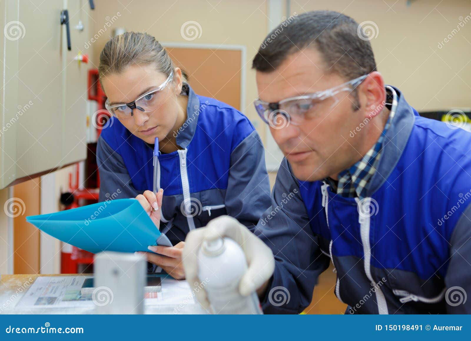 Engineer Using Pressurised Spray Female Colleague Taking Notes Stock ...