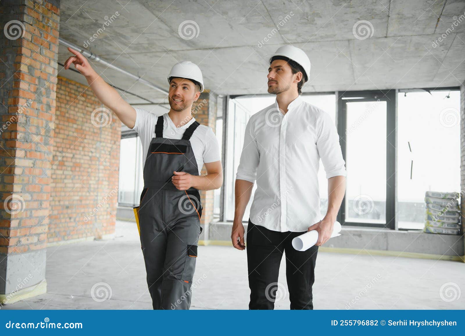 Engineer and Worker Checking Project at Building Site Background ...