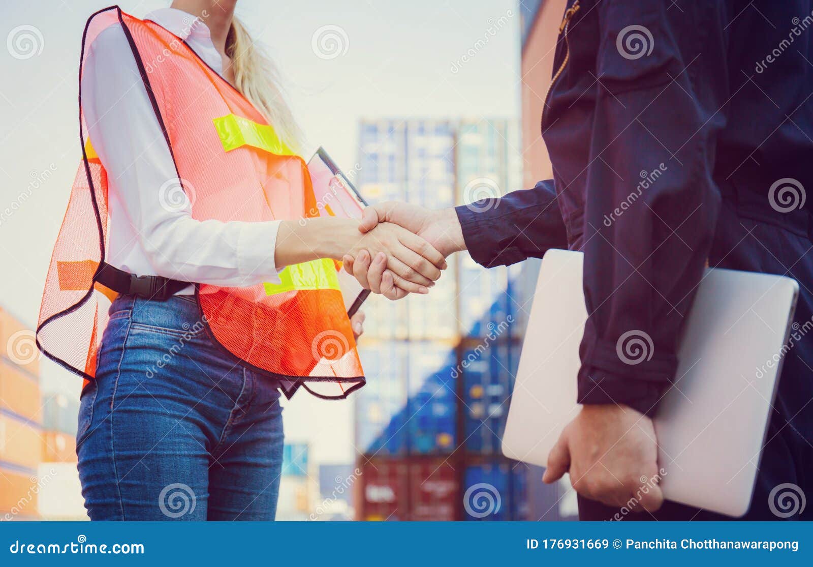 Engineer and Worker Handshake with Blurred Containers Cargo Background ...