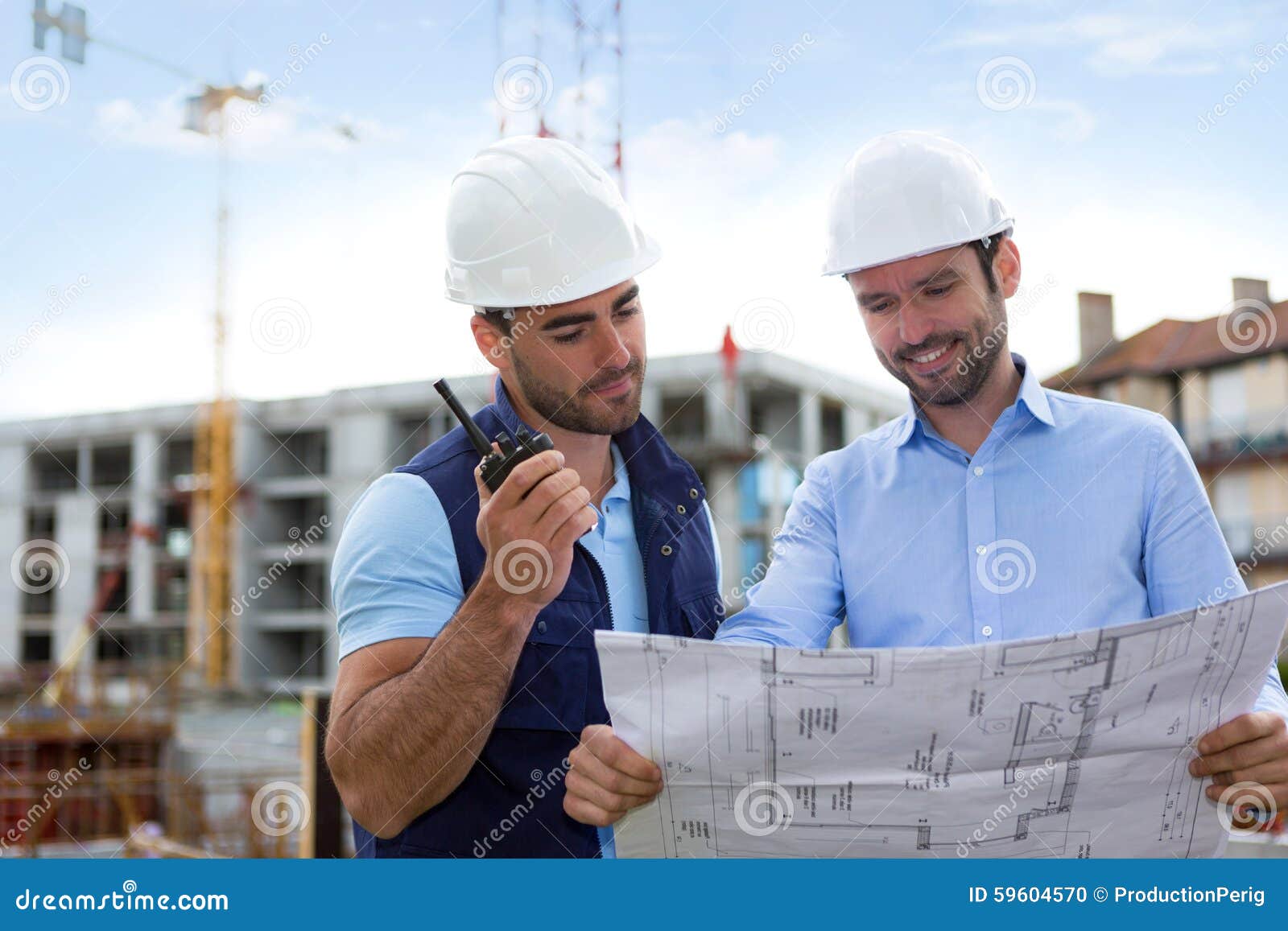 Engineer and Worker Watching Blueprint on Construction Site Stock Photo ...