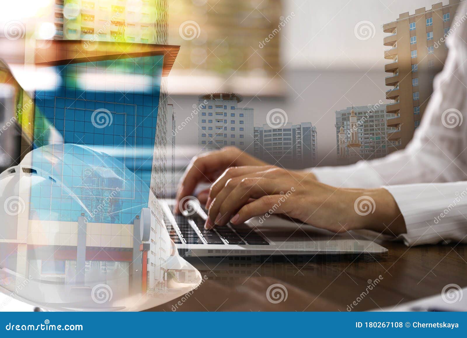 Engineer Working with Laptop at Table in Office and Modern Buildings ...