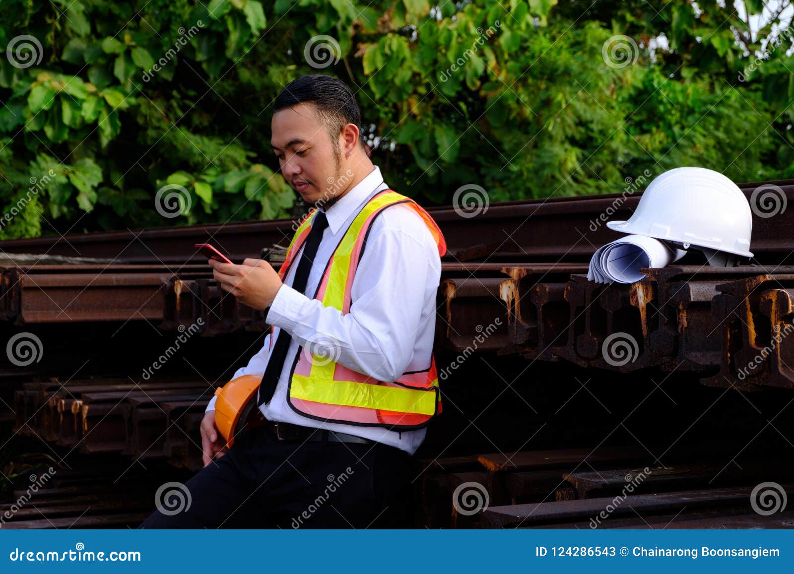 The Engineer is Working with Smart Phone with Large Industry Background ...