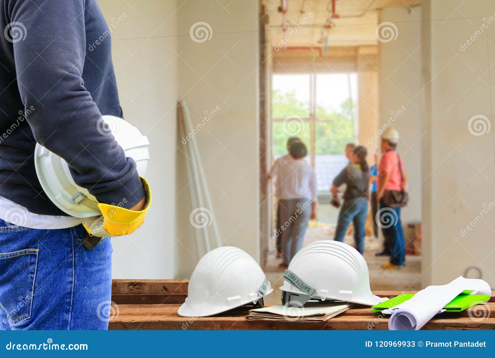 Engineering Hand Holding White Safety Hat And Paper Plan Blueprint On ...