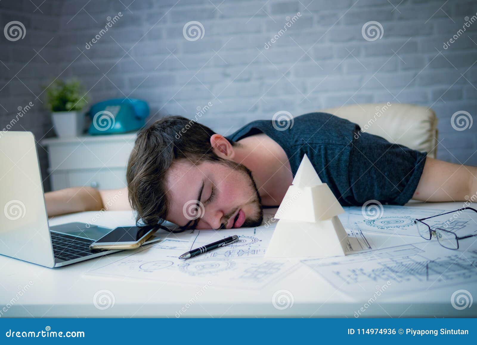 Engineering Man Working Overwork and Sleep on the Desk with Blue Stock ...