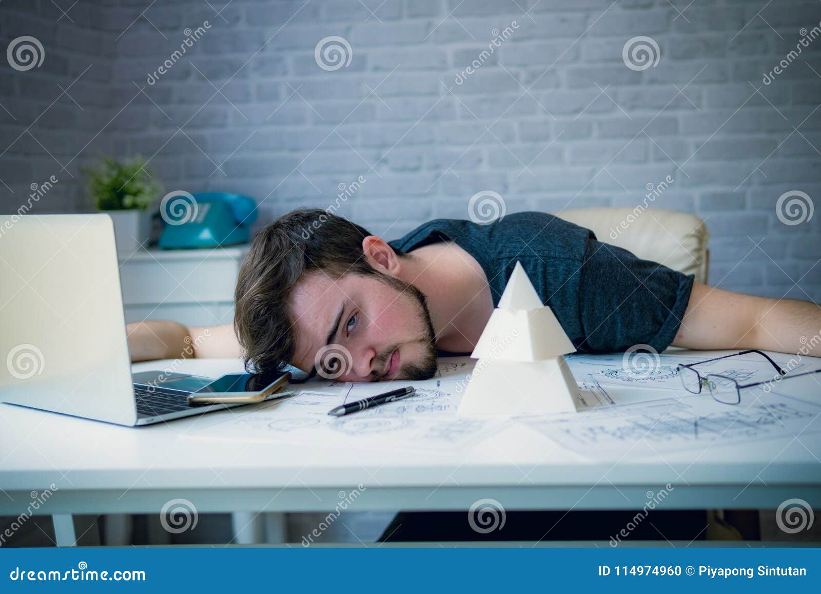 Engineering Man Working Overwork and Sleep on the Desk with Blue Stock ...
