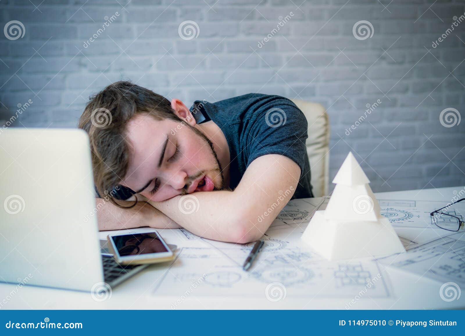 Engineering Man Working Overwork and Sleep on the Desk with Blue Stock ...
