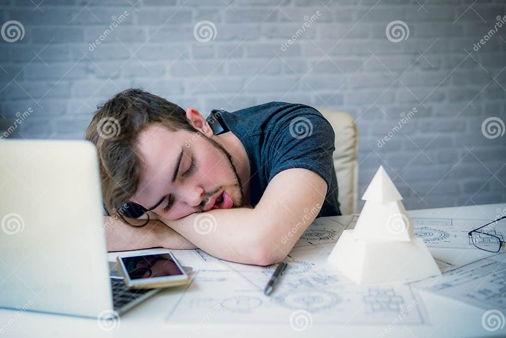 Engineering Man Working Overwork and Sleep on the Desk with Blue Stock ...