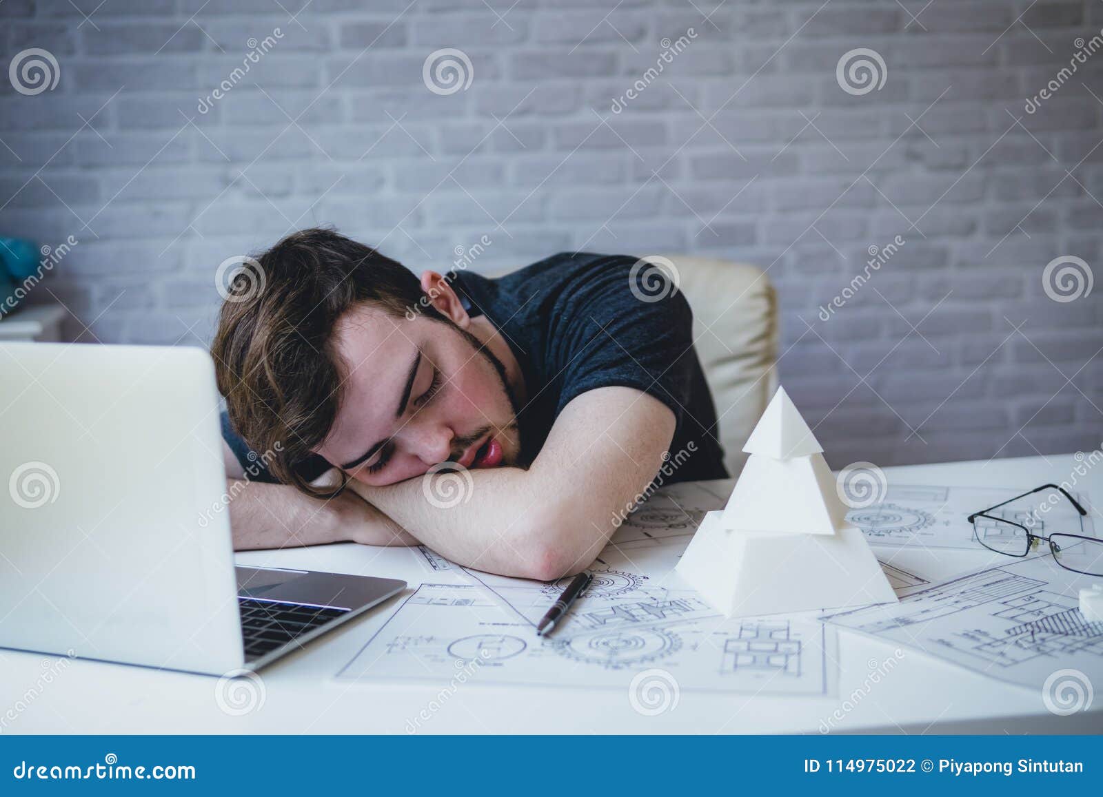 Engineering Man Working Overwork and Sleep on the Desk with Blue Stock ...