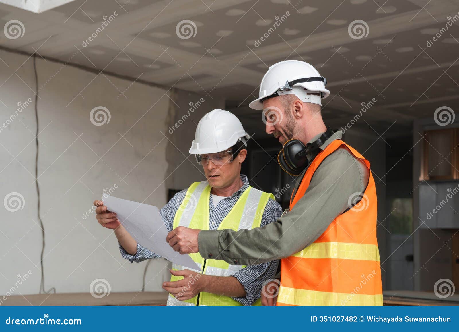 Engineering Team Planning Construction Work with Blueprints and Safety ...