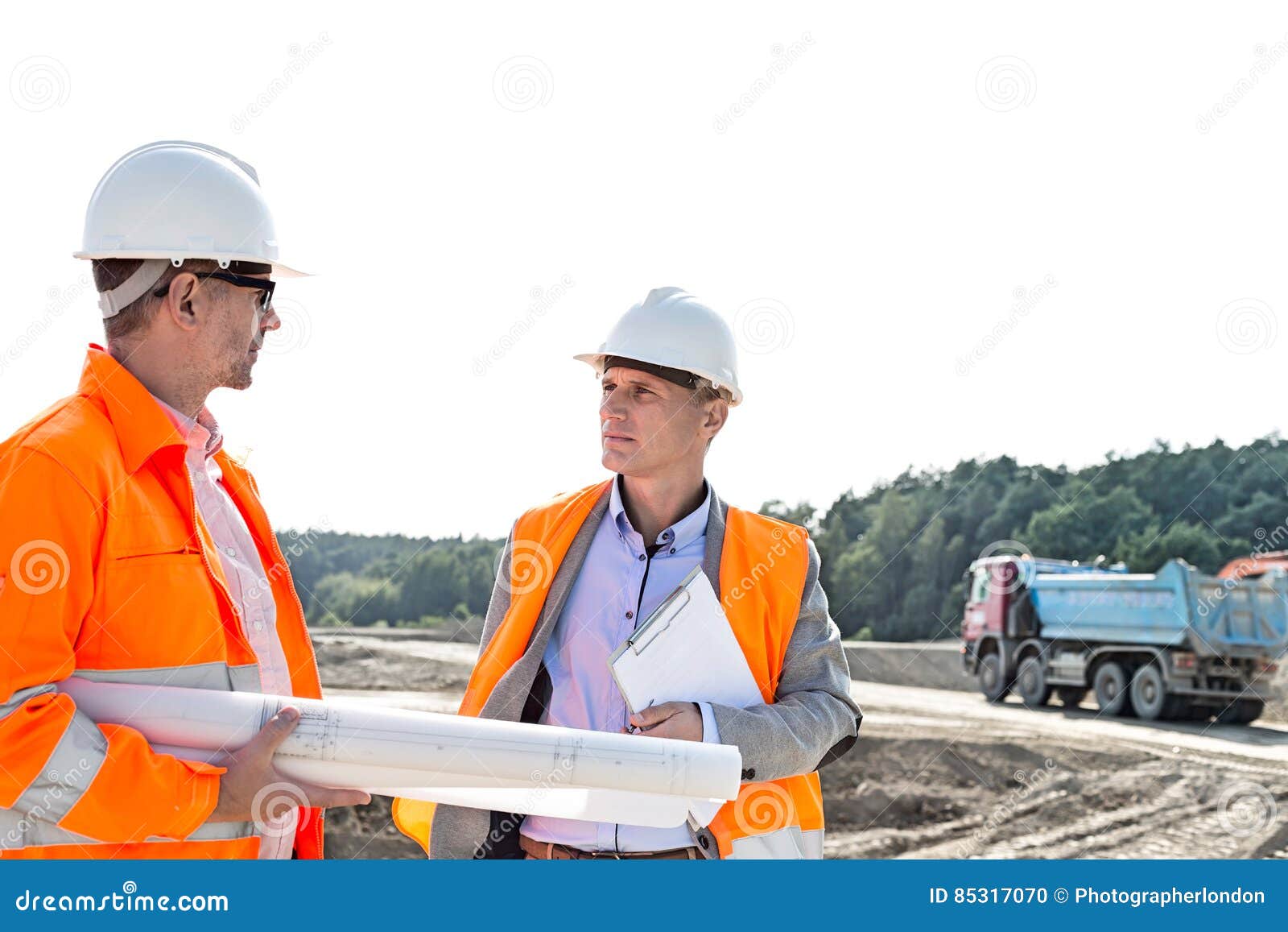 Engineers Discussing at Construction Site Against Clear Sky Stock Photo ...