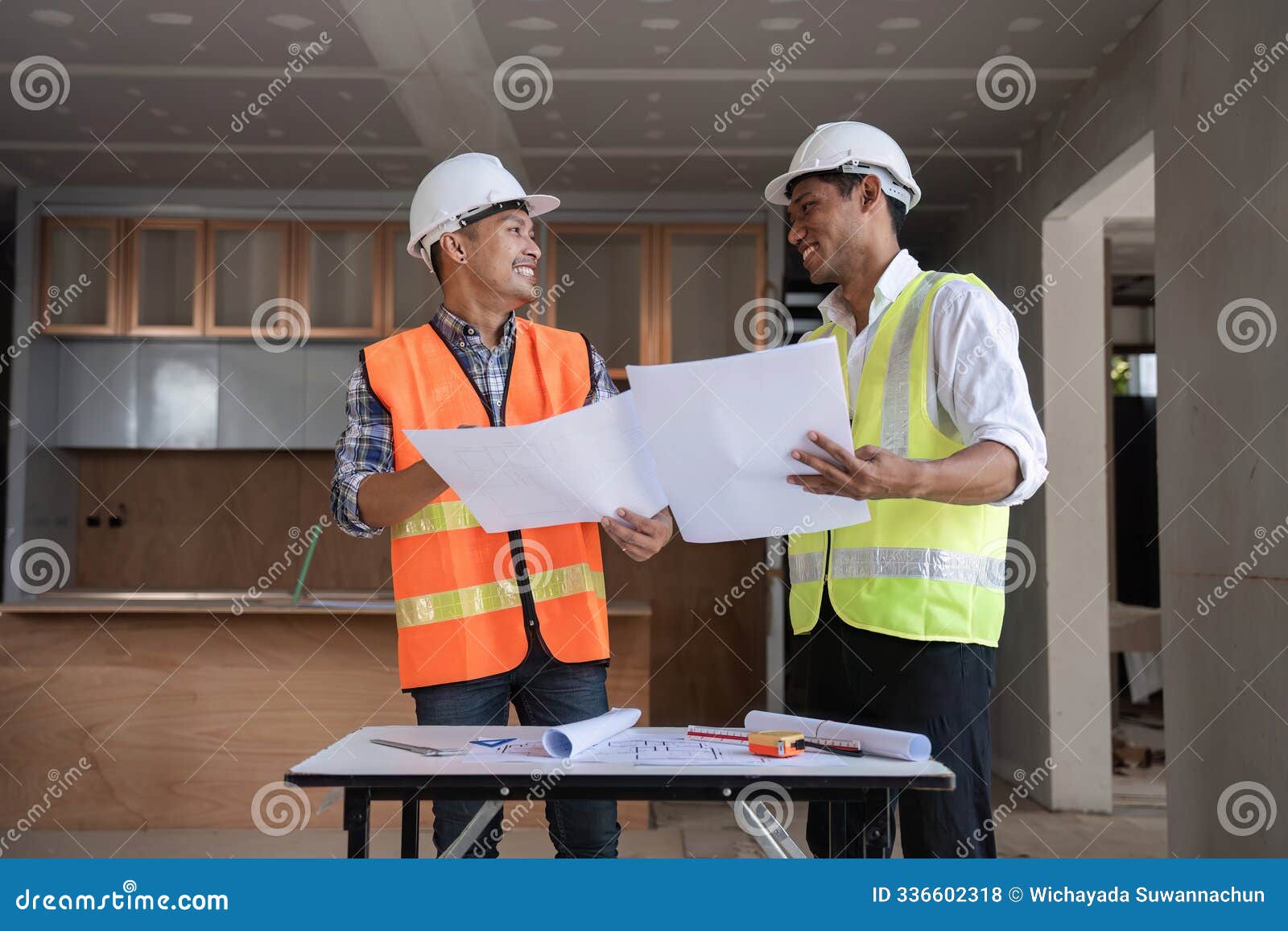 Engineers Discussing and Planning Construction Project while Holding ...