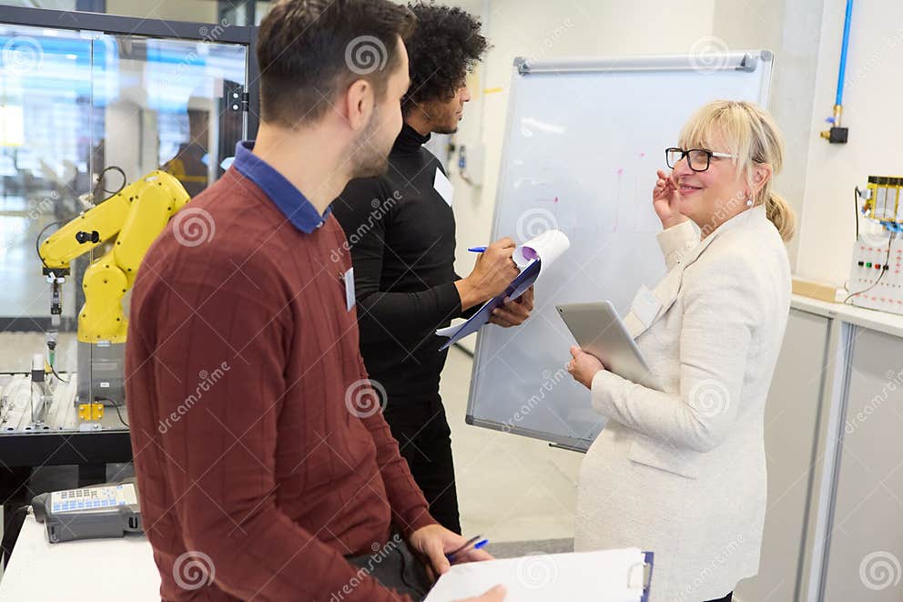 Engineers Discussing Robot Automation and Programming in a Modern Industrial Setting Stock Photo ...