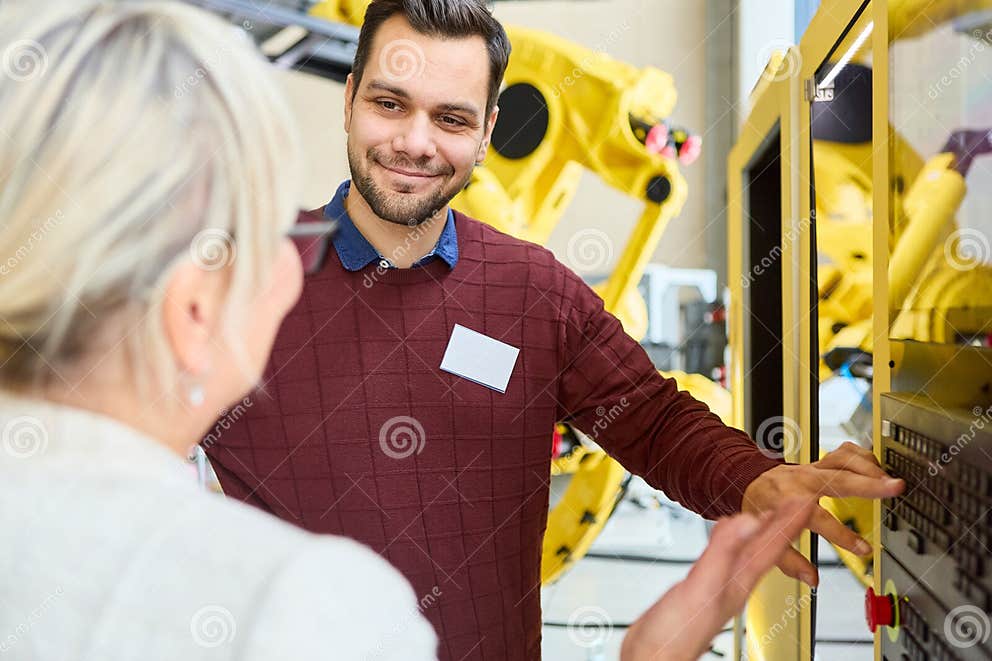 Engineers Discussing Robotics Programming with Multi-purpose Robot in Background Stock Photo ...