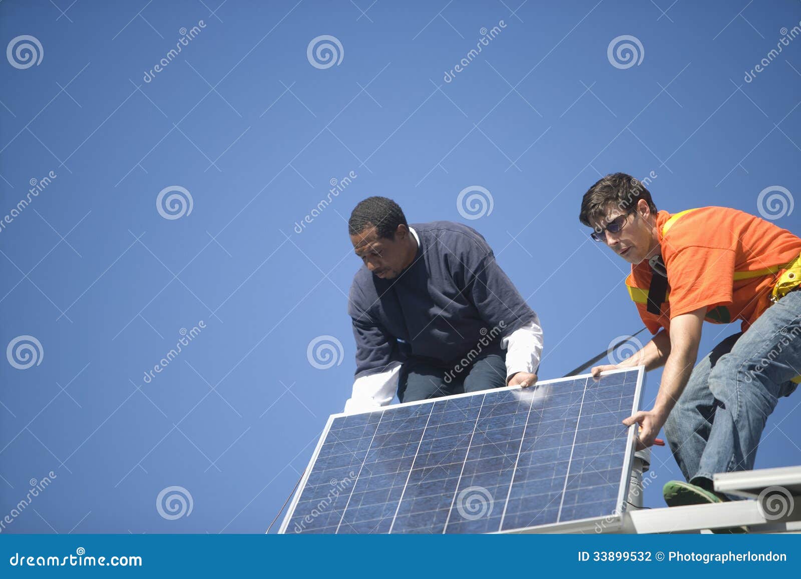 Engineers Fixing Solar Panel Against Blue Sky Stock Photo - Image of ...