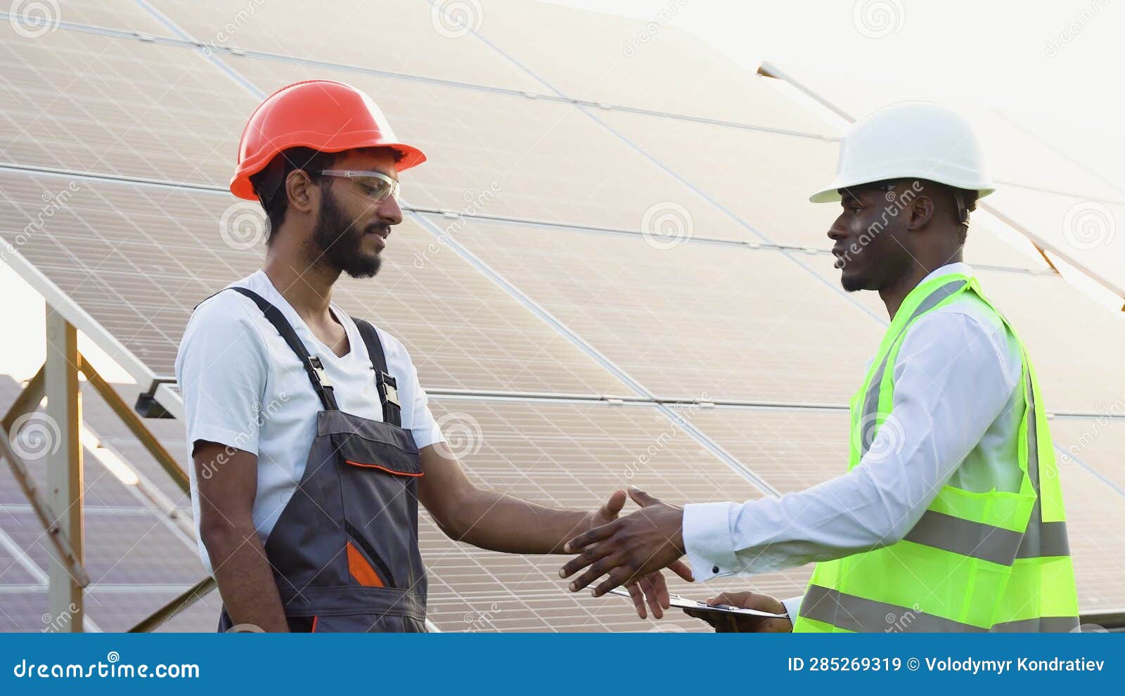 Indian and African Engineers Handshaking in Front of Solar Panels Stock ...