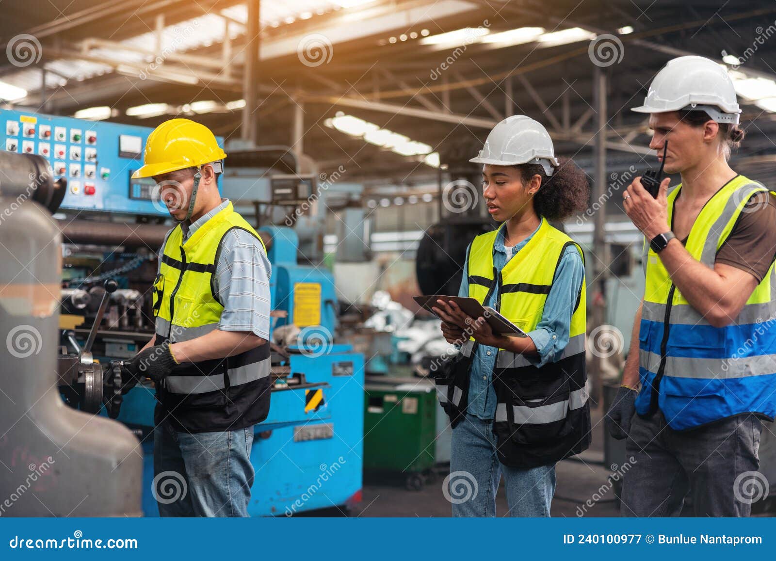 Engineers in an Industry Plant Setting Up Machines Vs a Background of a ...