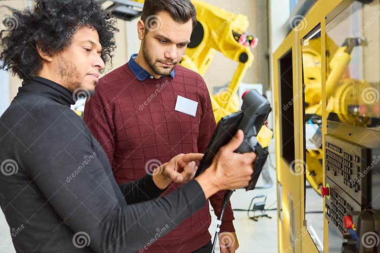 Engineers Programming Industrial Robot with Control Panel for Precision ...