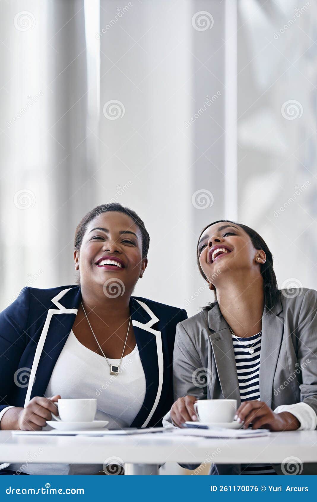 Enjoying A Laugh Between Meetings Two Coworkers Laughing Together