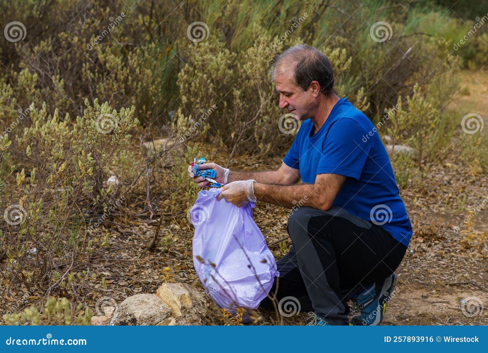 Environmentalist Man Picking Up Garbage from the Field Stock Photo ...