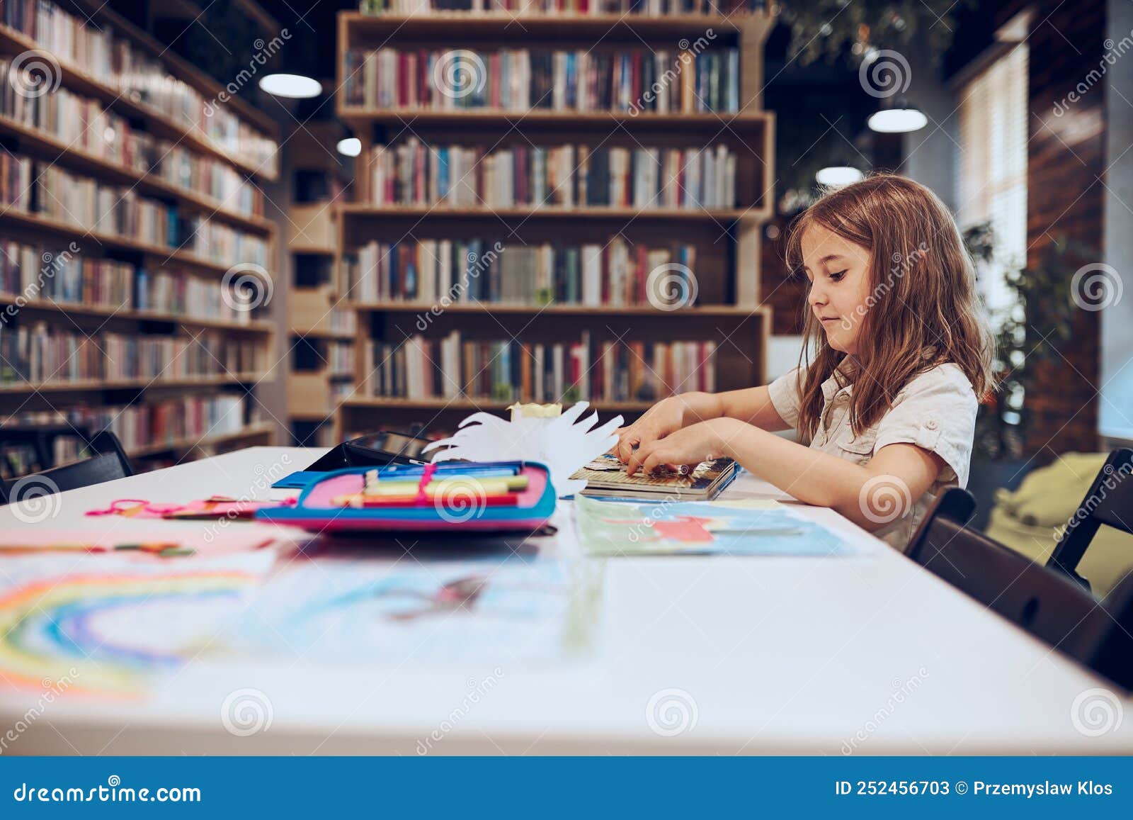 Escolares Aprendiendo a Jugar Puzzles Y Leyendo Libros En La Biblioteca ... Escolares Aprendiendo a Jugar Puzzles Y Leyendo Libros En La Biblioteca ...