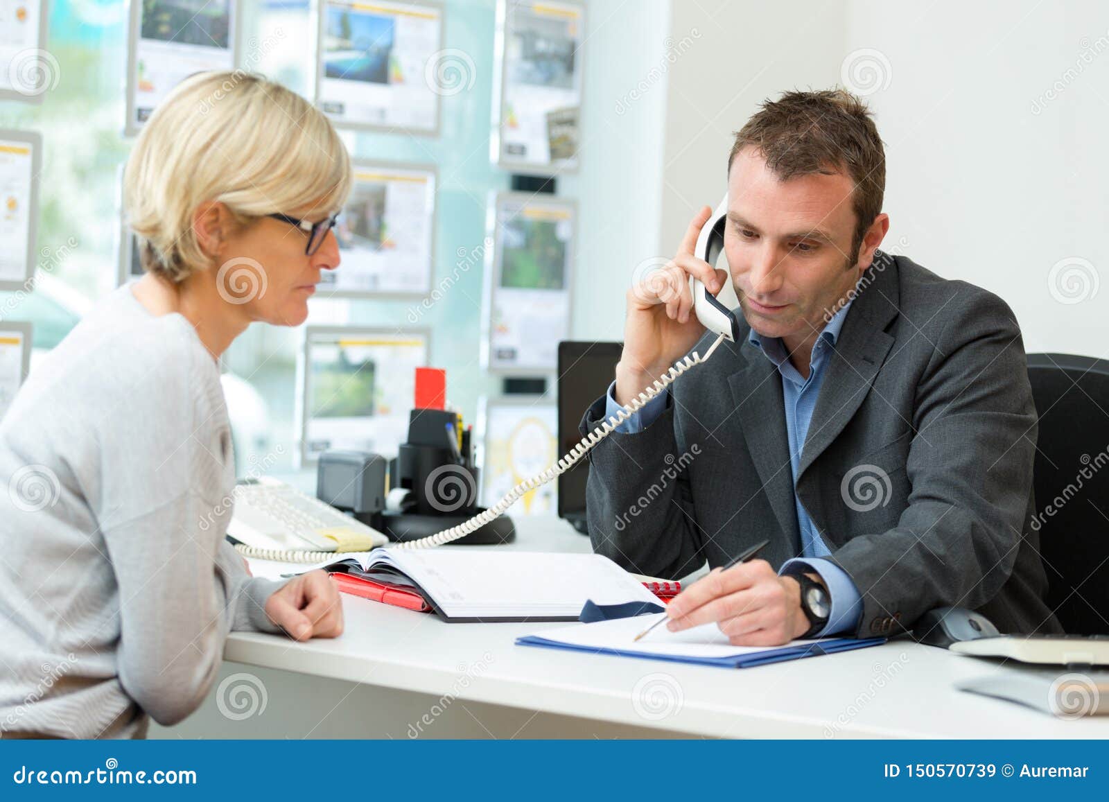 Estate Agent in Office with Client Talking on Landline Stock Image ...