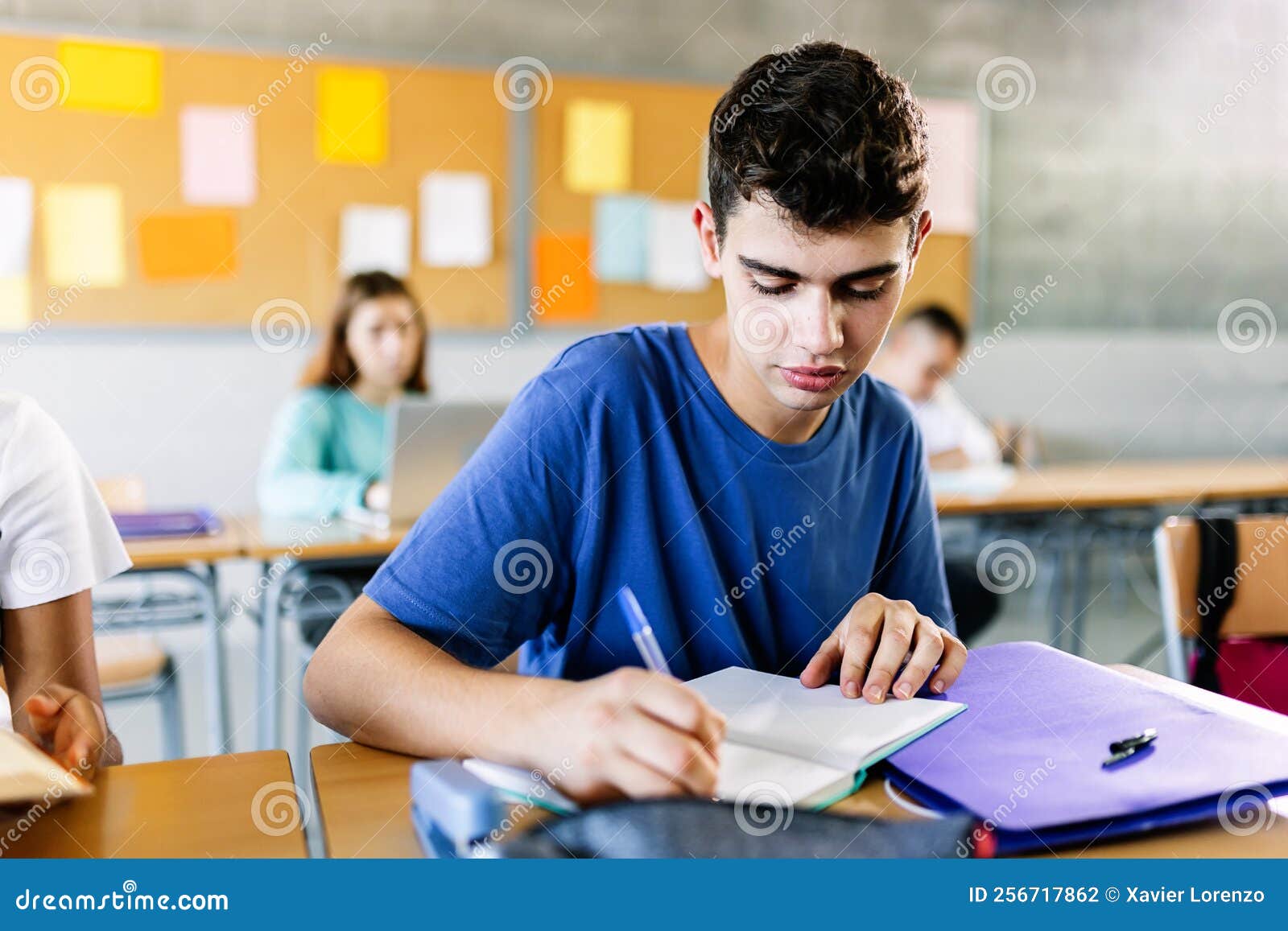Estudiante Joven De Secundaria Escribiendo Para Un Bloc De Notas En ... Estudiante Joven De Secundaria Escribiendo Para Un Bloc De Notas En ...