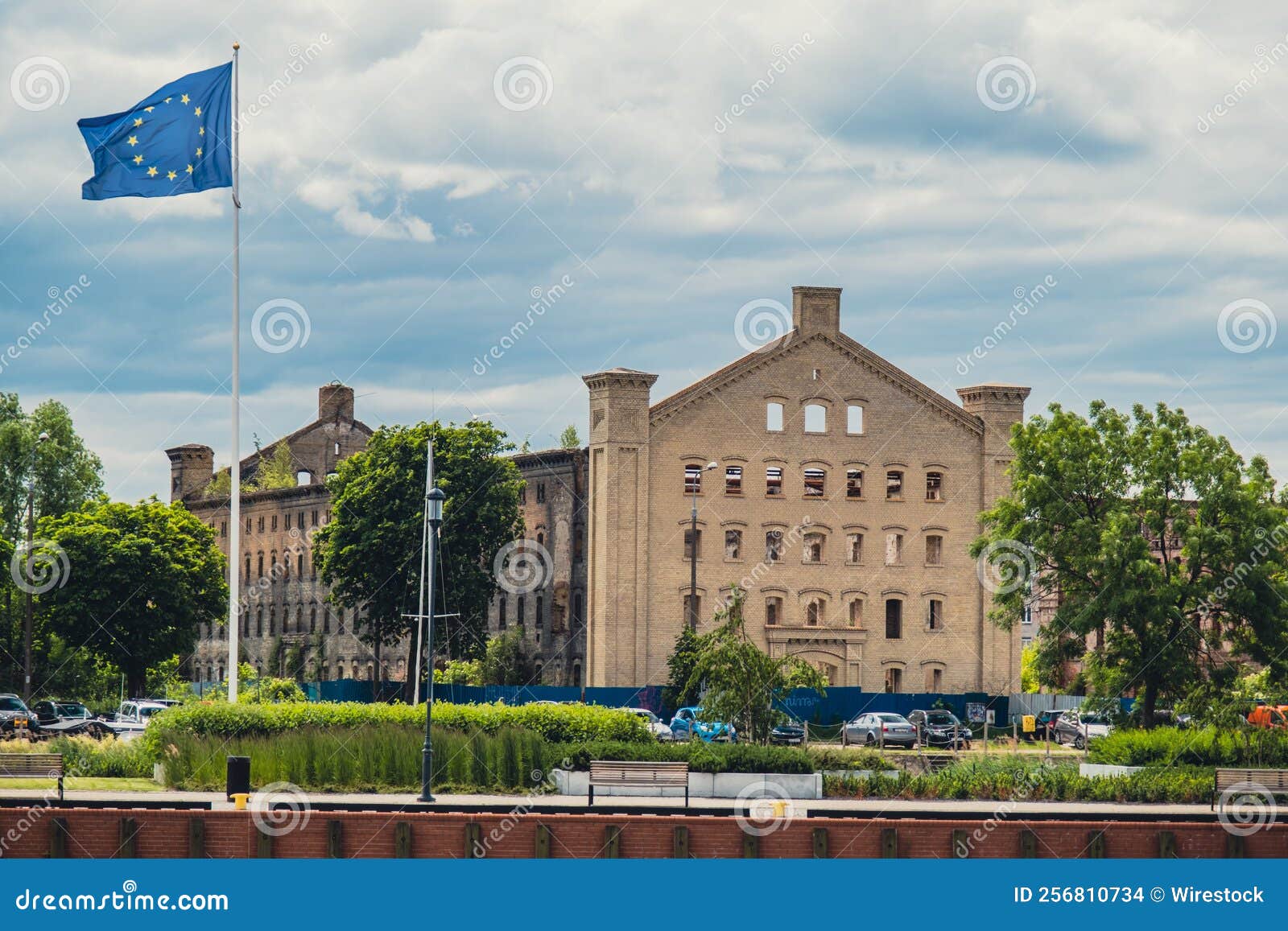 EU Flag Hanging on the Pole, with an Abandoned Harbor Building in the ...