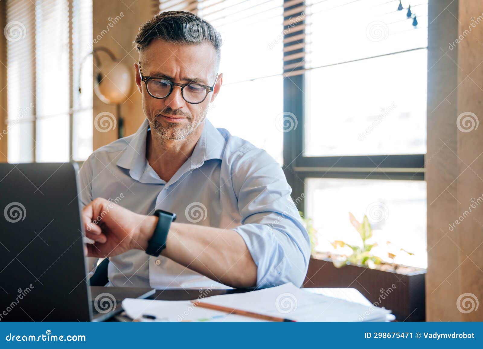European Grey Man Looking at Smartwatch while Working at Office Stock ...