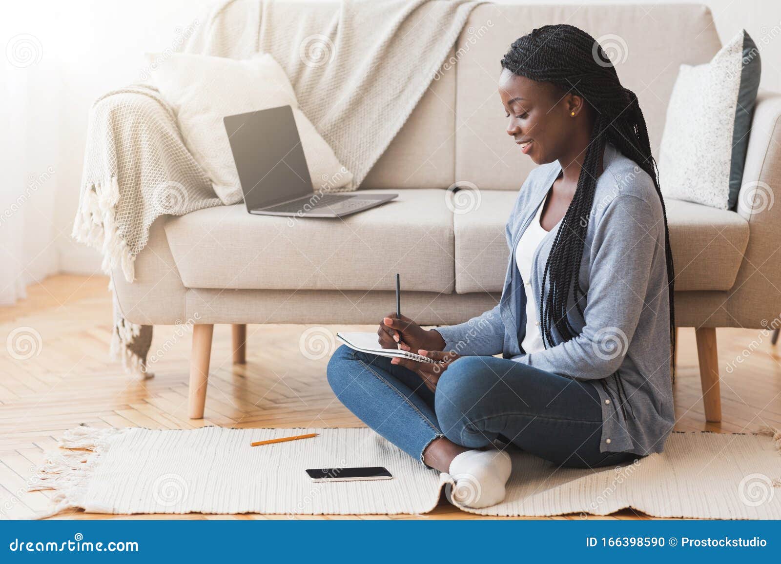 Black Female Student Taking Notes while Studying at Home with Laptop ...