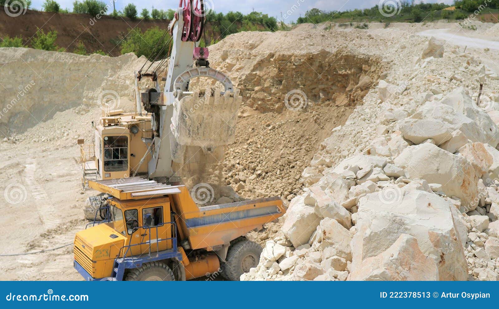 An Excavator in Action on a Construction Site. an Excavator and a Truck ...
