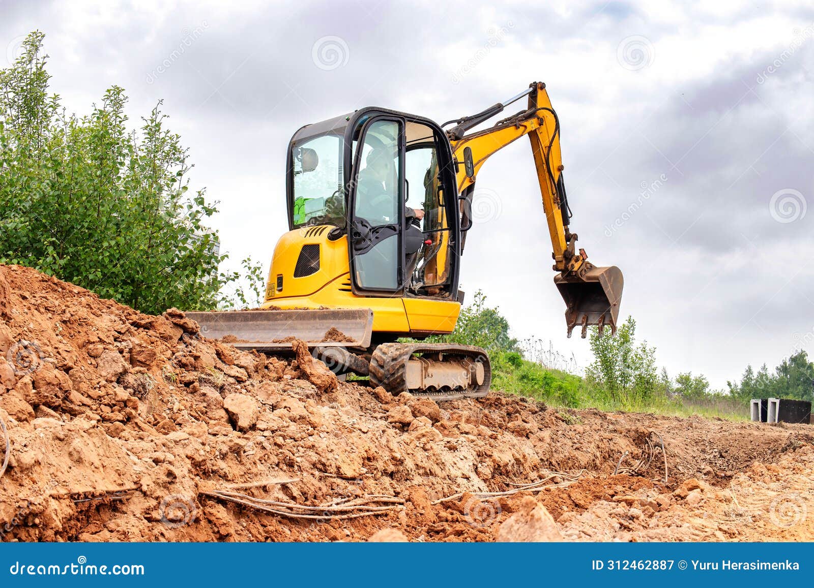 A Excavator Actively Digging through a Mound of Soil and Dirt, Creating ...
