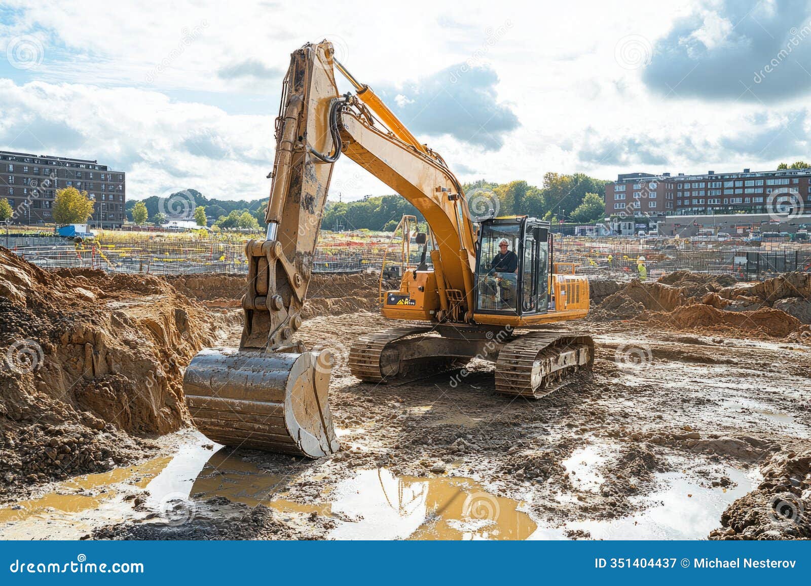Excavator Digging on Muddy Construction Site with Building Foundations ...