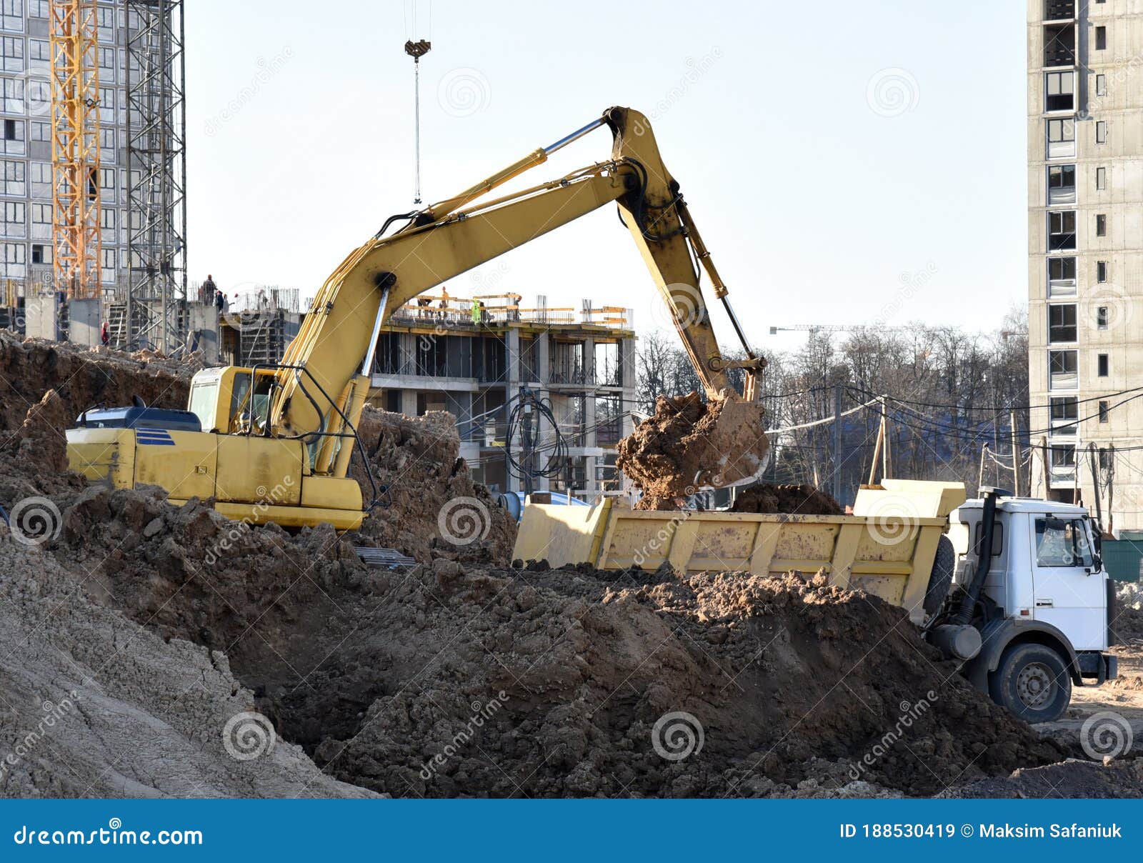 Excavator Digging Sand and Loading into Dump Truck on Construction Site ...